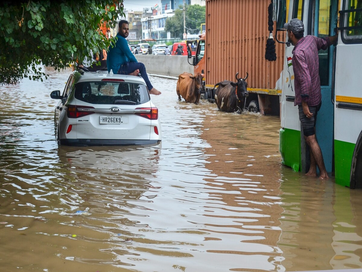 In Pics: Commuters Struggle Through Waterlogged Areas After Heavy Rains Lash Gurugram - News18