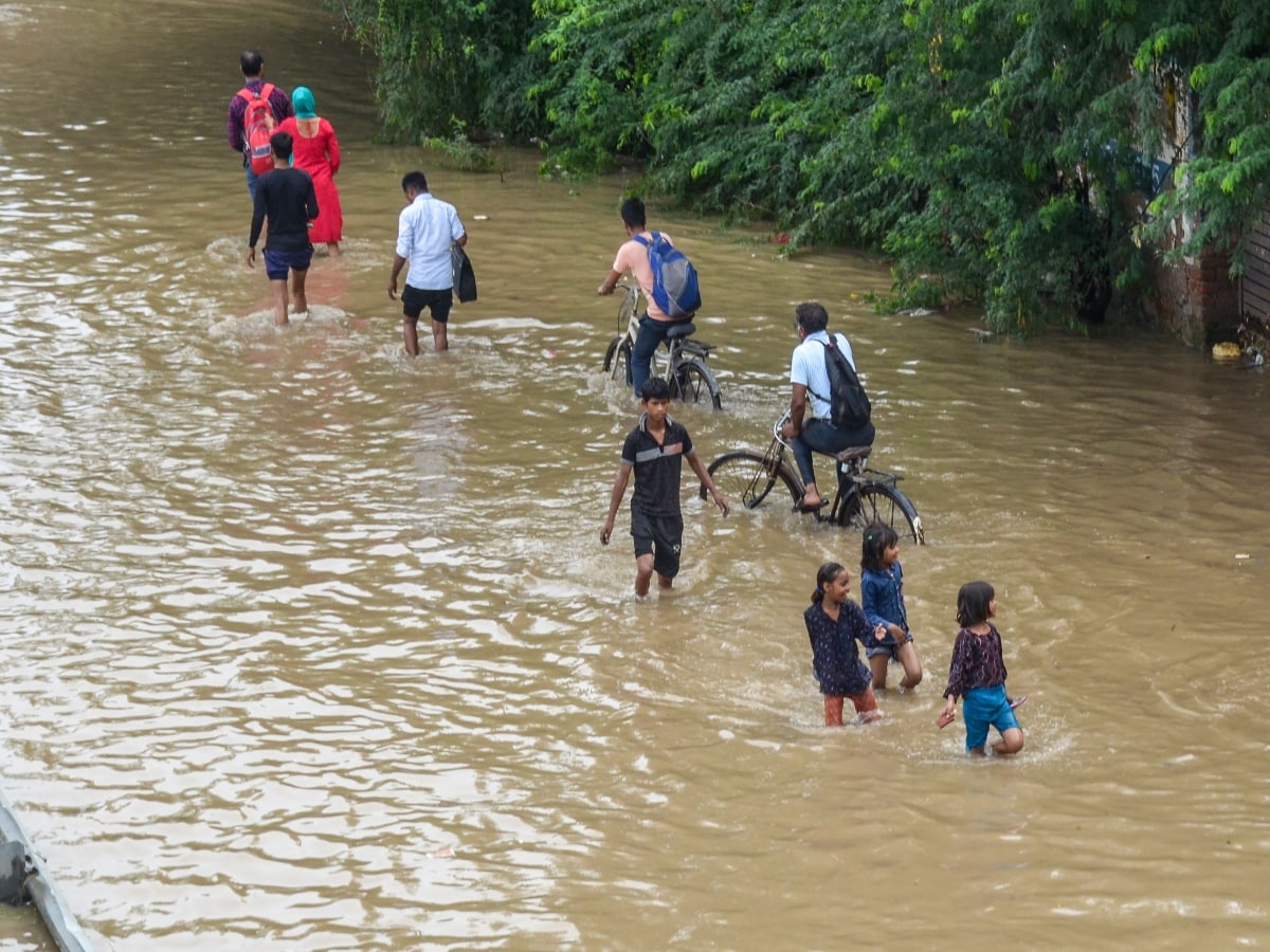In Pics: Commuters Struggle Through Waterlogged Areas After Heavy Rains Lash Gurugram - News18