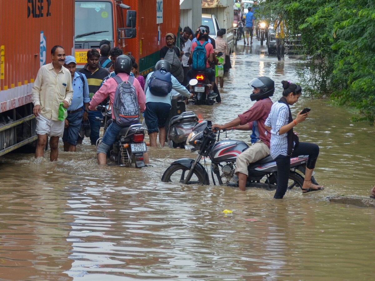 In Pics: Commuters Struggle Through Waterlogged Areas After Heavy Rains Lash Gurugram - News18