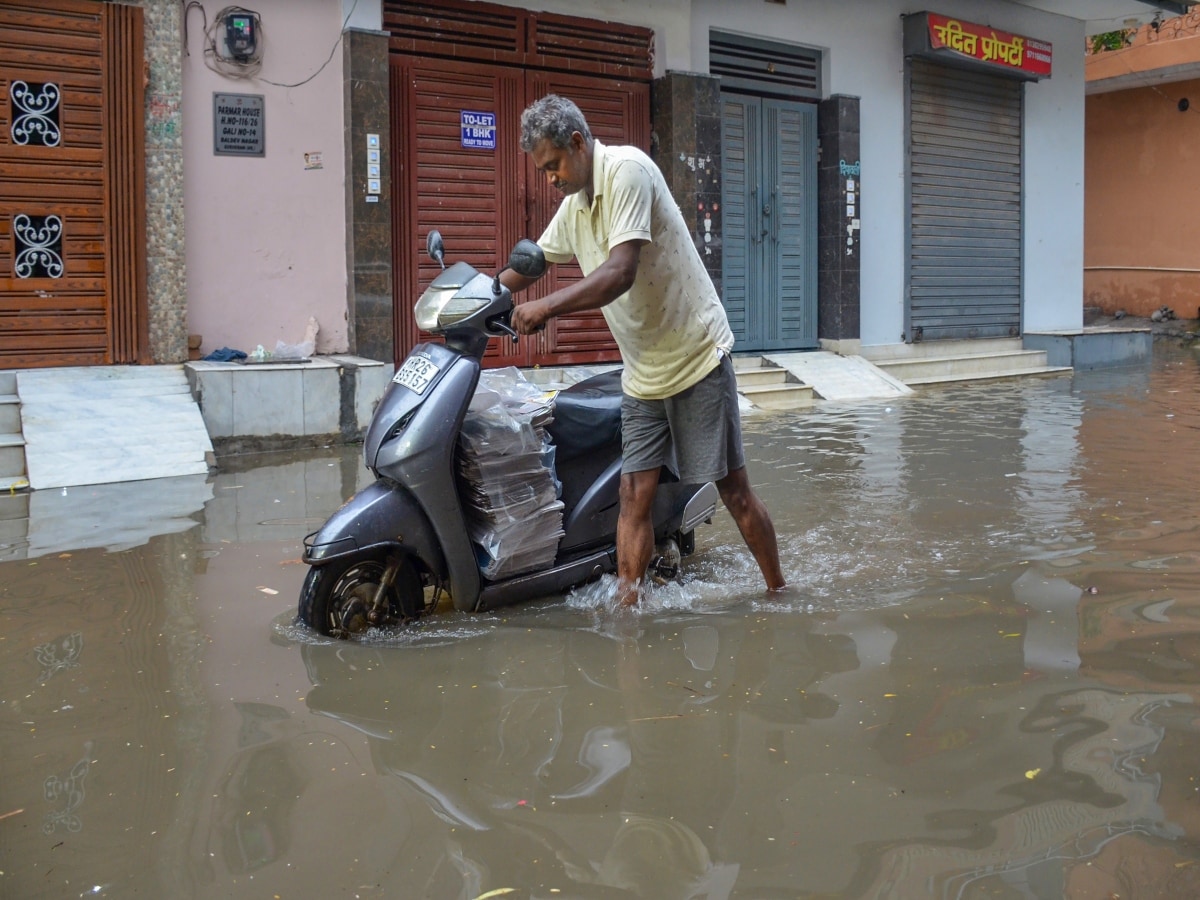 In Pics: Commuters Struggle Through Waterlogged Areas After Heavy Rains Lash Gurugram - News18